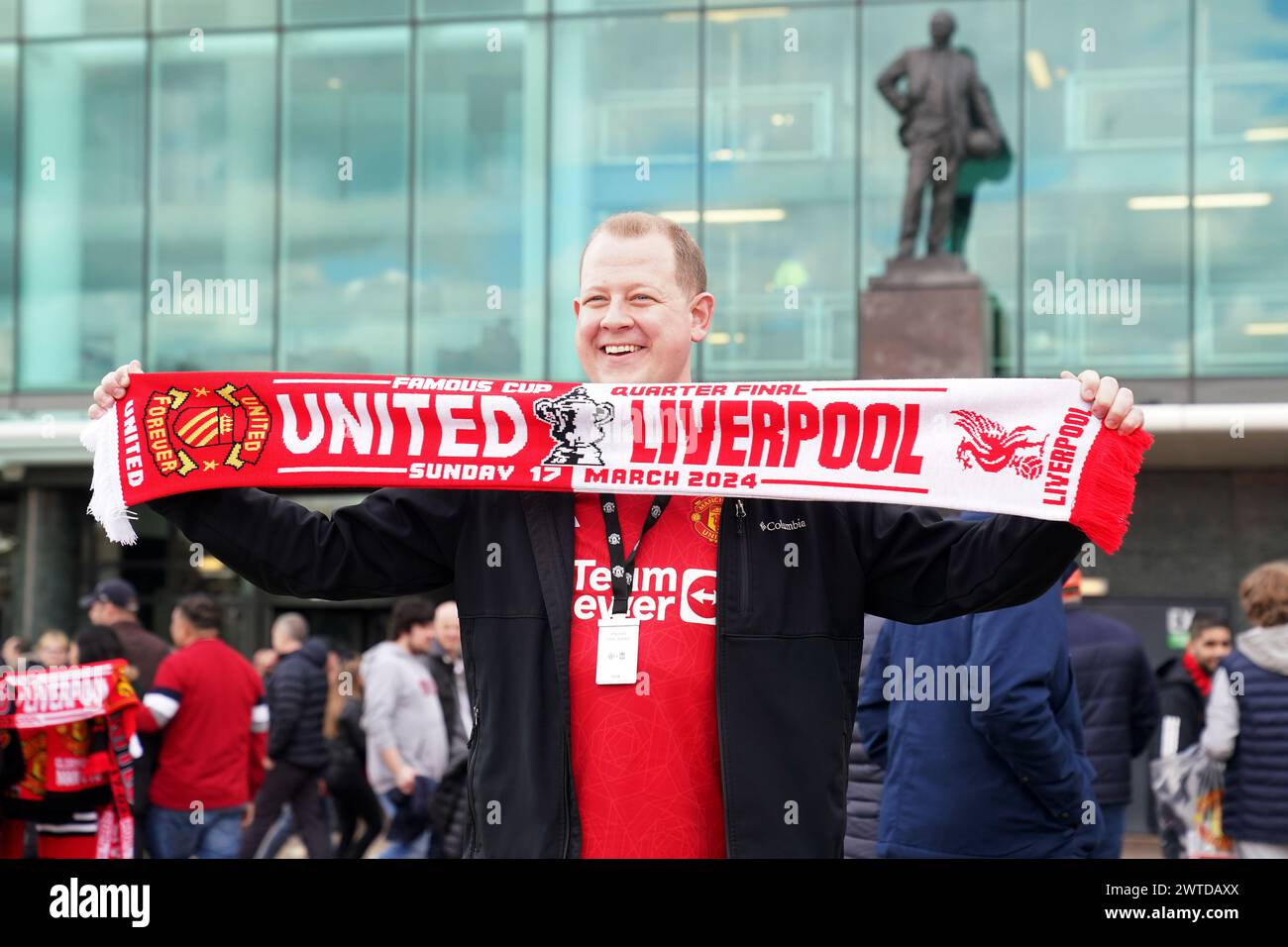 A Manchester United fan holds up a half & half scarf outside the ...