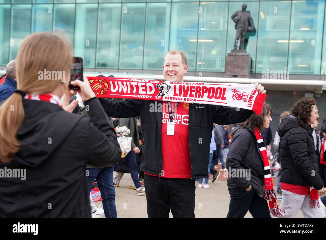 A Manchester United fan holds up a half & half scarf outside the ...