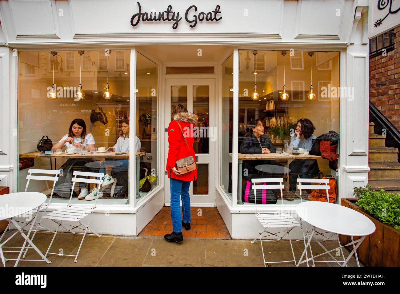 woman in red coat entering the Jaunty Goat coffee shop in the cheshire ...