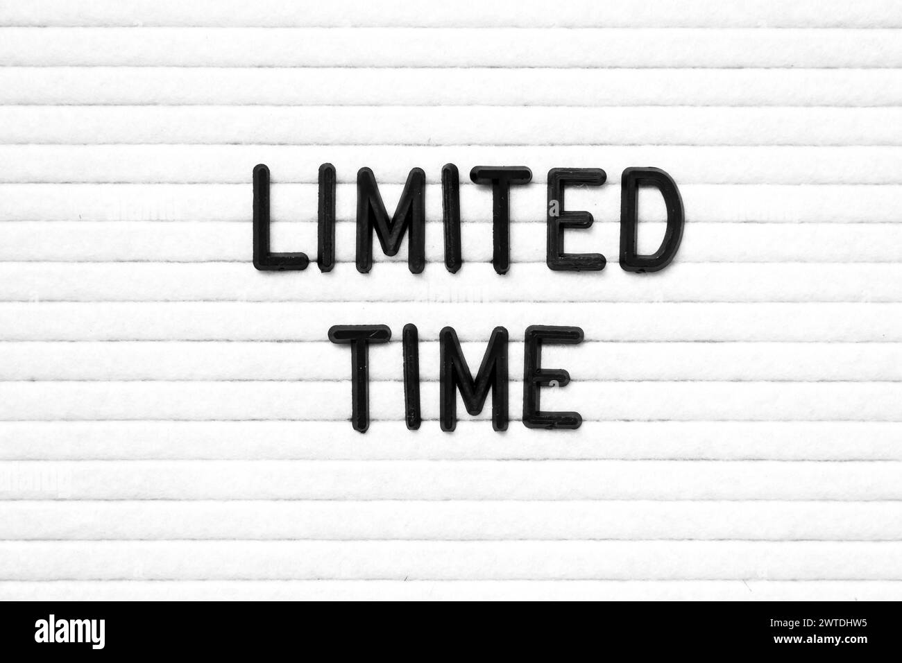 Black color letter in word limited time on white felt board background ...