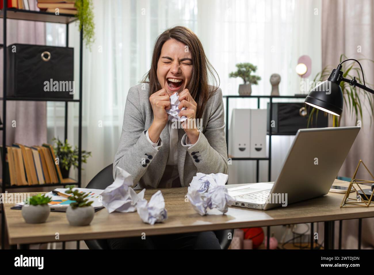 Angry furious business woman working at home office throwing crumpled ...