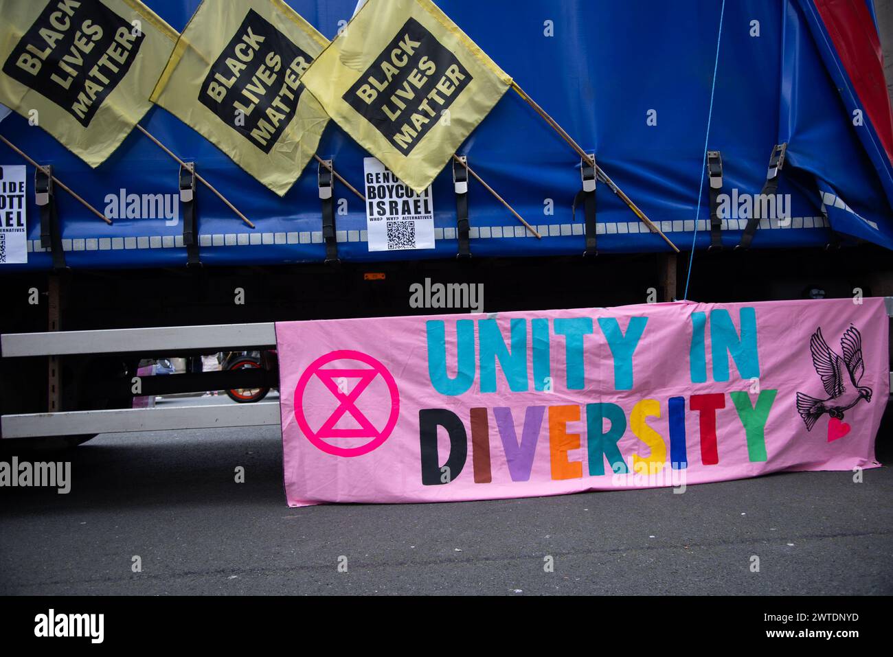 Flags and a large banner are displayed on the music sound system truck ...