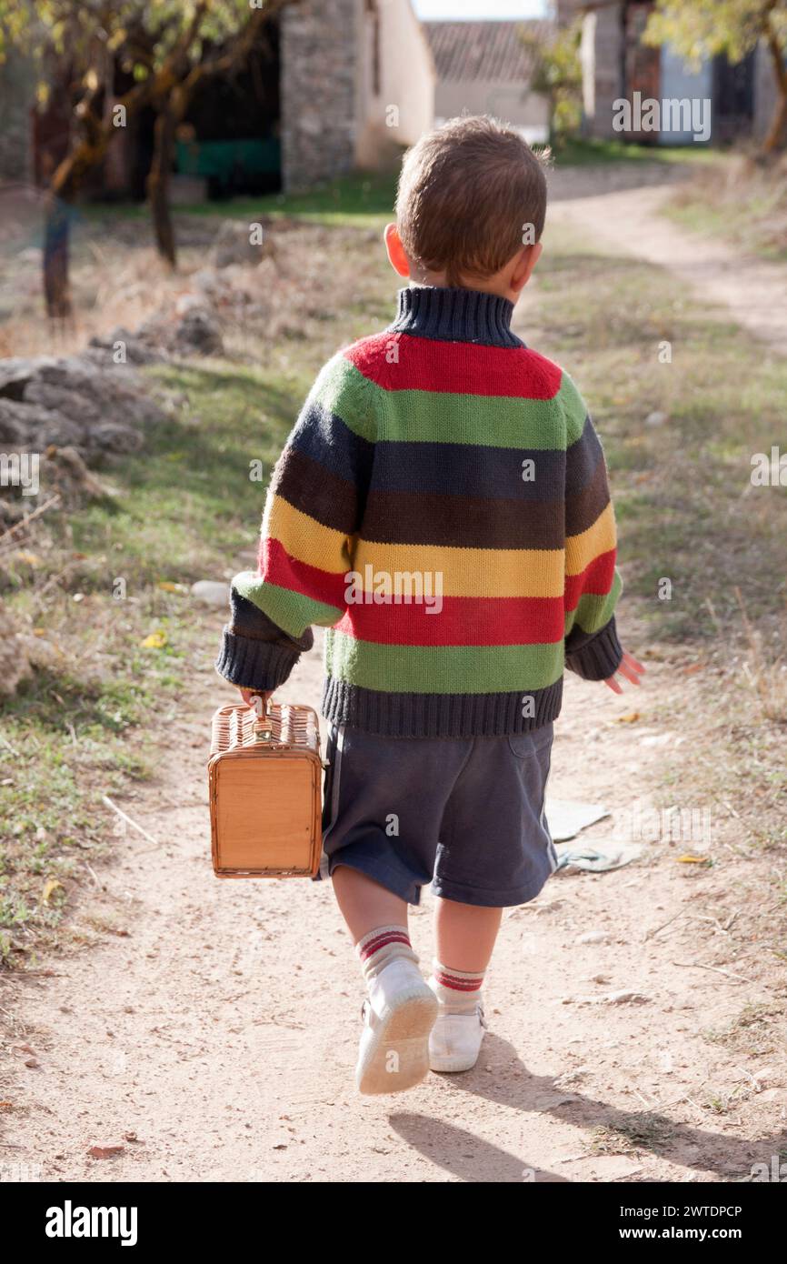 back of little boy carrying a basket up dusty path Stock Photo - Alamy