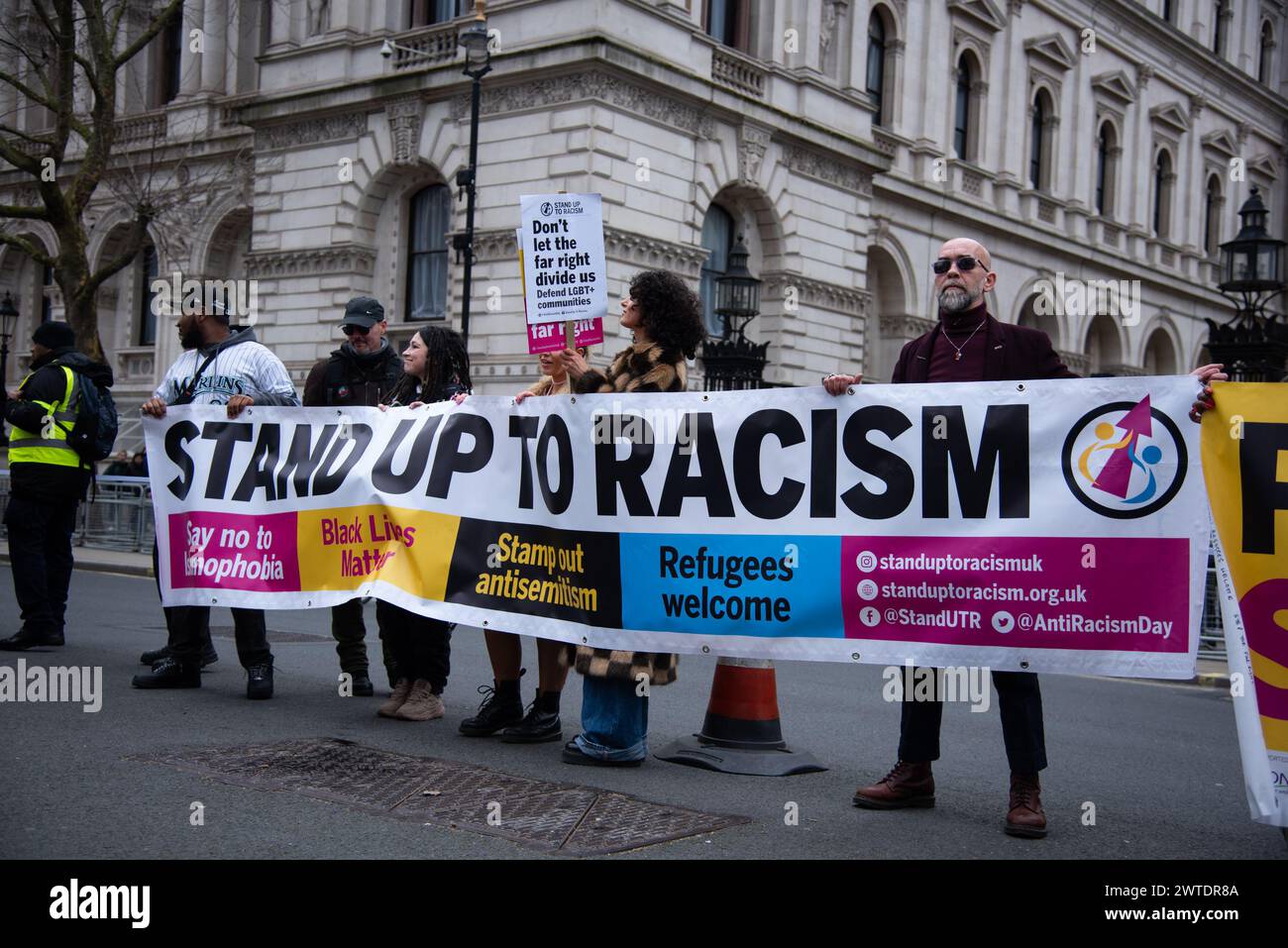 London, UK. 16th Mar, 2024. Protestors march with a large banner and a ...