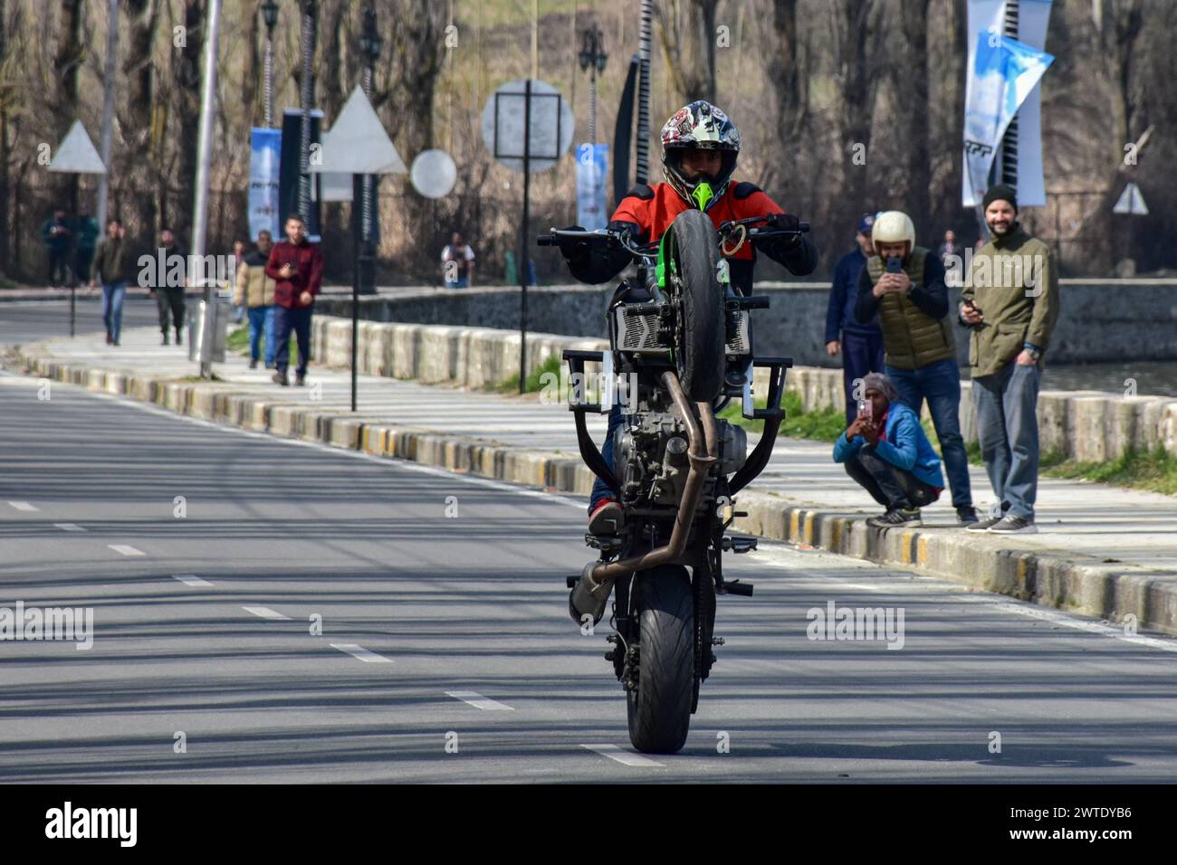 Srinagar, India. 17th Mar, 2024. A professional bike rider performs a stunt during a motorsport ...