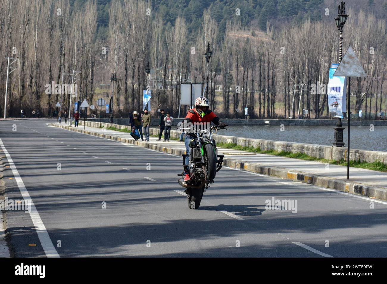 Srinagar, India. 17th Mar, 2024. A professional bike rider performs a stunt during a motorsport ...