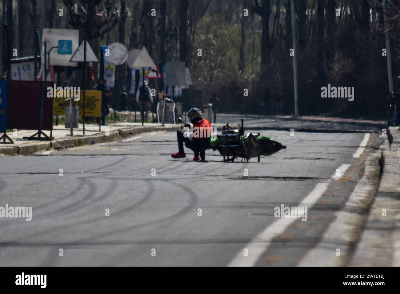 Srinagar, India. 17th Mar, 2024. A professional rider reacts after a crash in a race during a ...