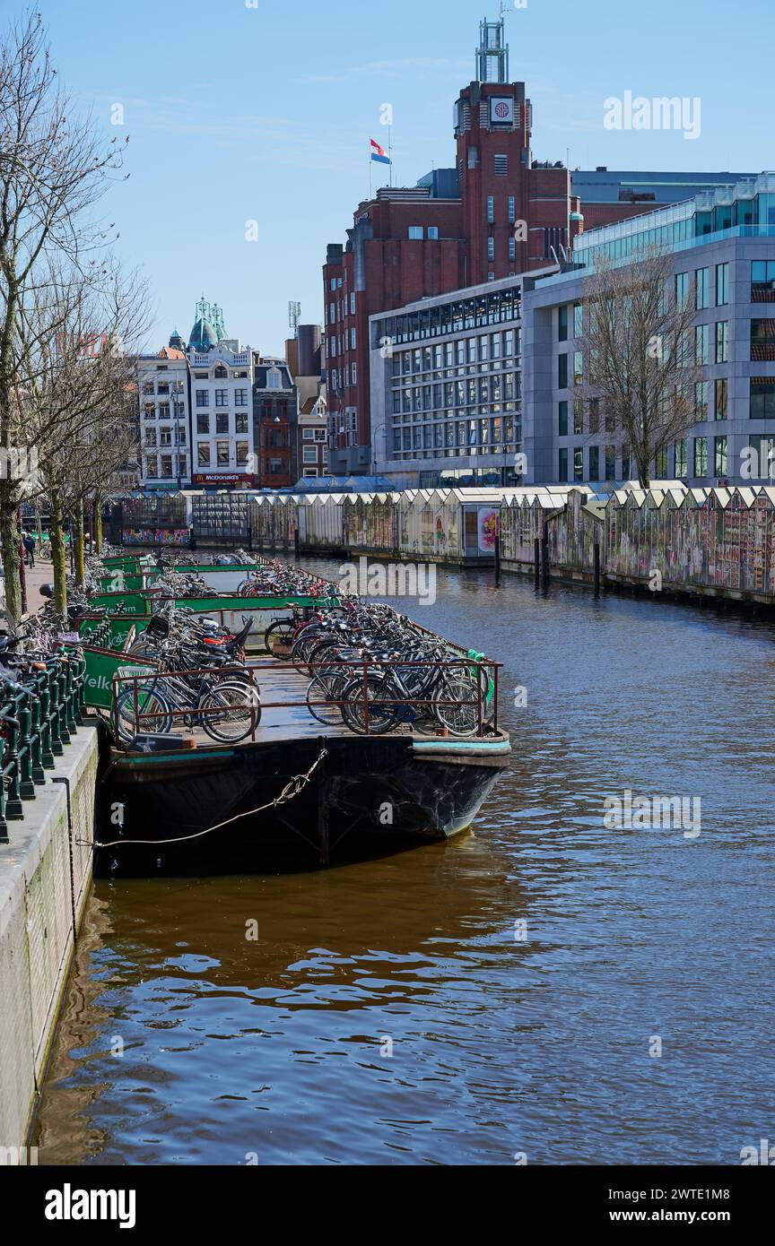 occupied bicycle parking spaces on a canal in Amsterdam city center ...