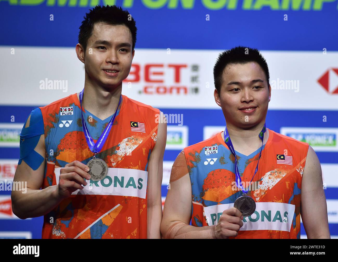 Malaysia's Aaron Chia and Soh Wooi Yik, left, pose with silver medals after the men's doubles ...
