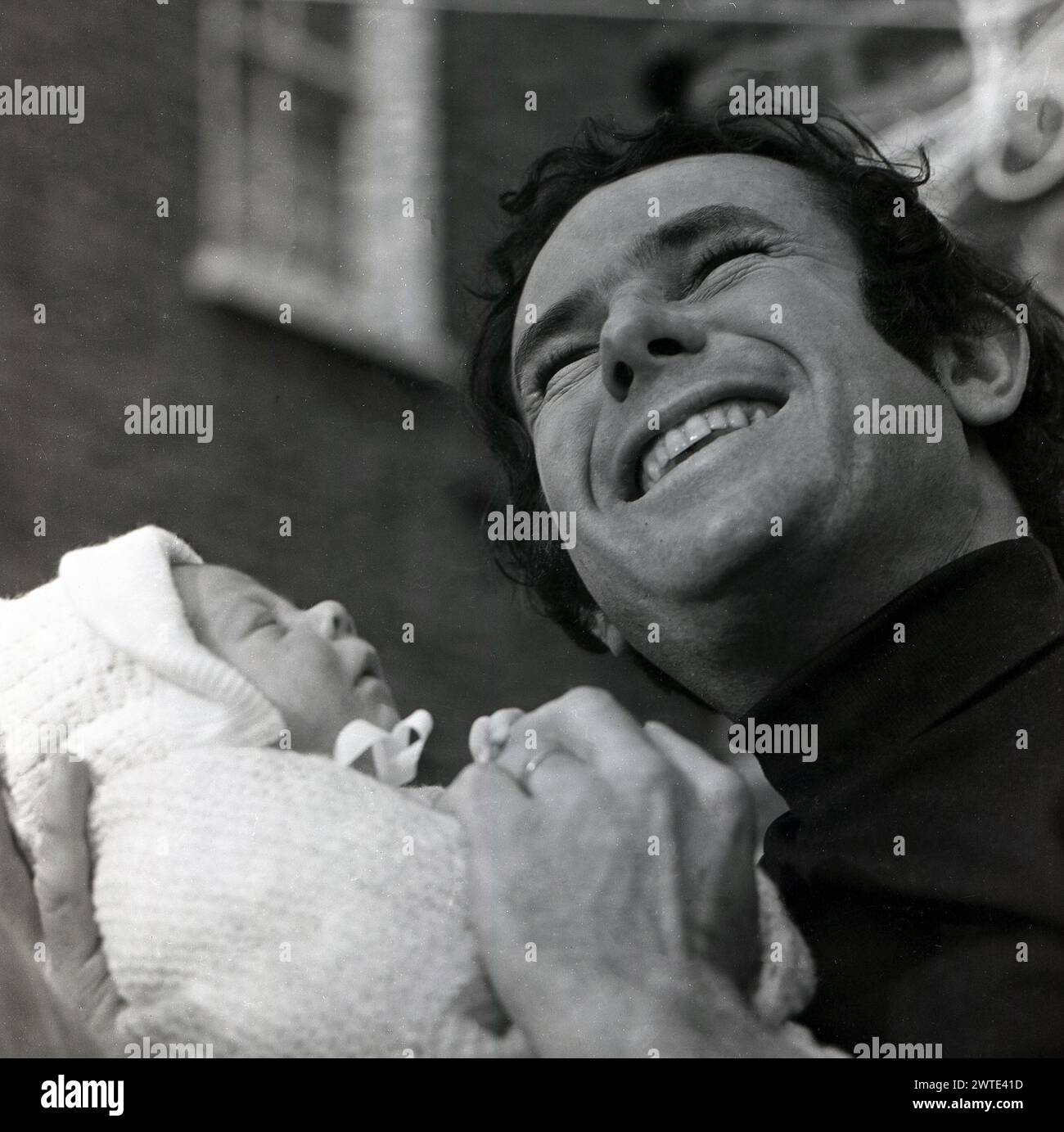 1970s, historical, a new father showing pure joy on his face as he ...
