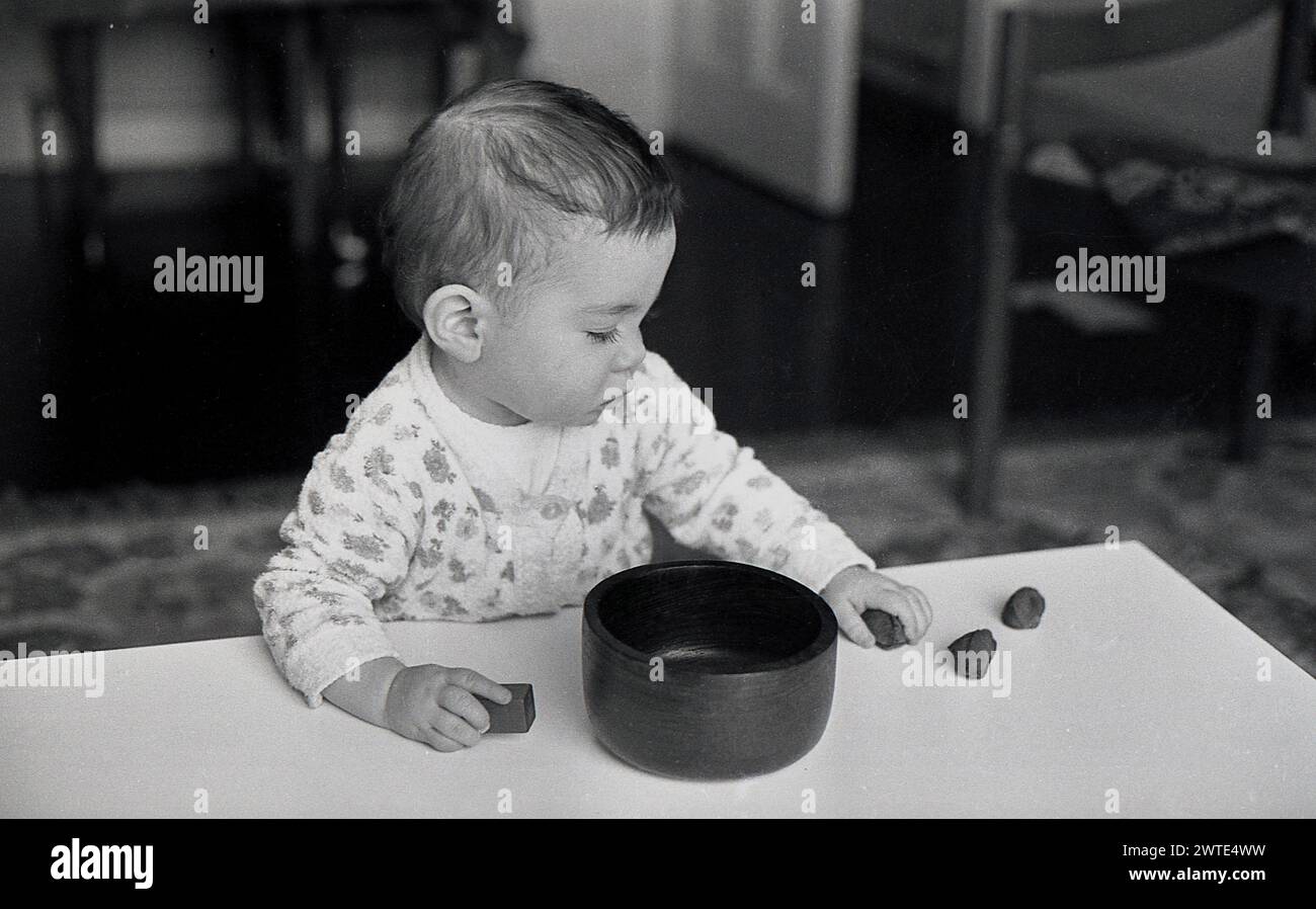 1970s, historical, infant child, little boy, at a table playing with ...