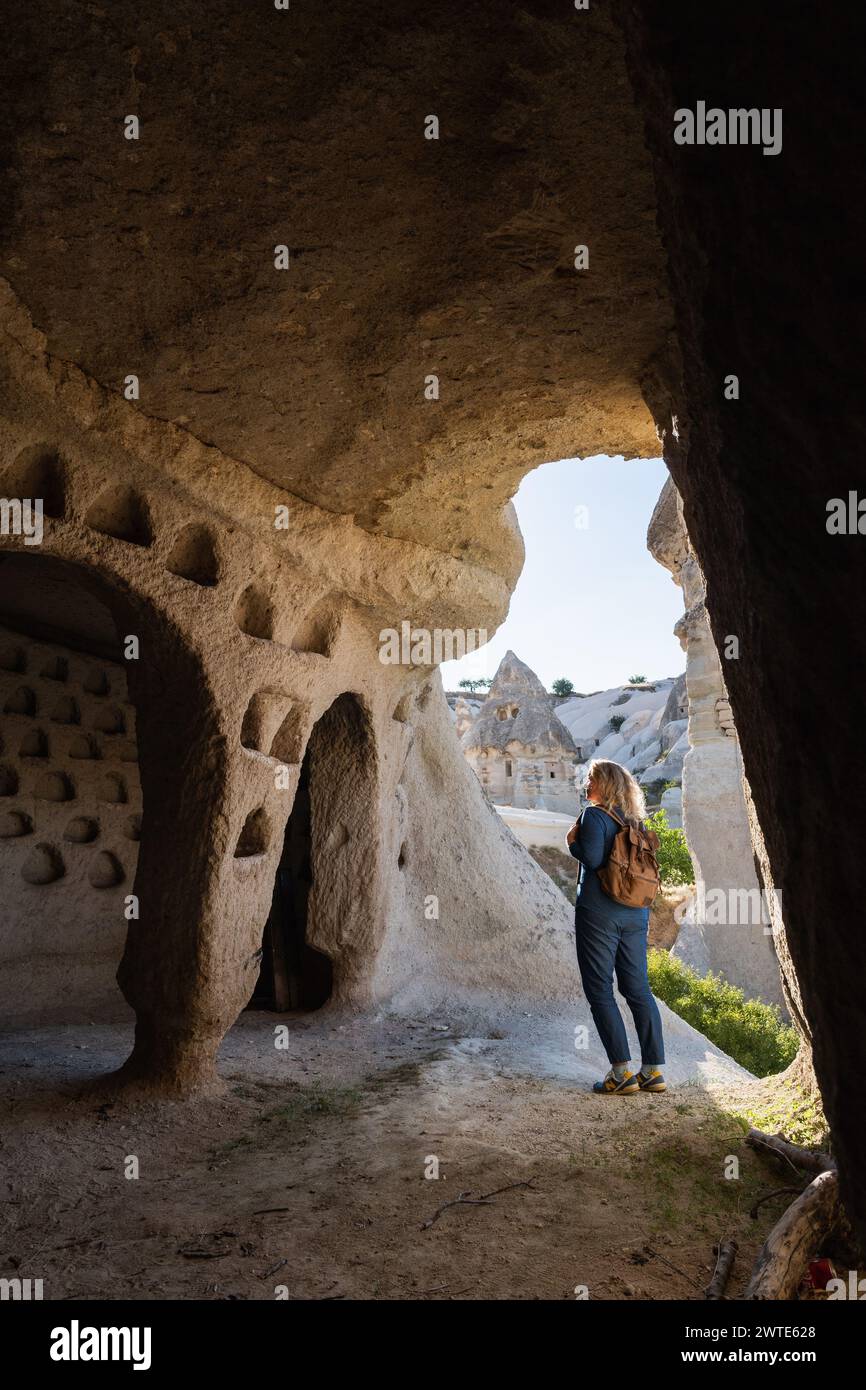 Woman travelling in Cappadocia, discovering the caves with the view of ...