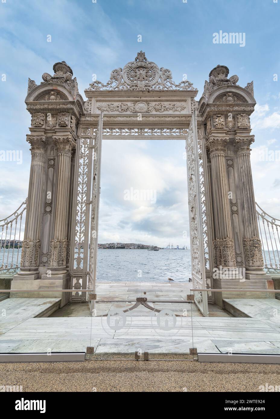 Pair of elaborately decorated white painted metal gates leading to the ...