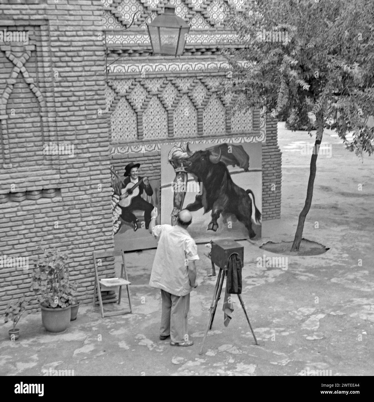 A street scene with a photographer taking a ‘head in the hole’ type ...