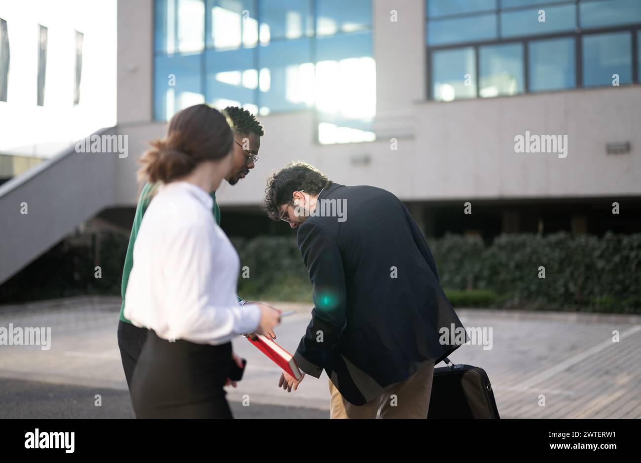 Professional greeting outside office building, exchanging a handshake ...
