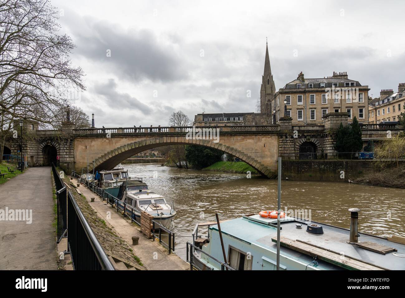 Stone bridge with arches over a river in bath, surrounded by classic ...