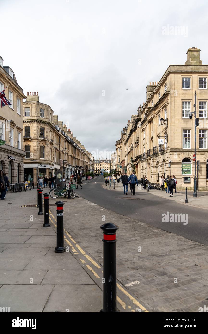 Pedestrians wander down a classic european city street lined with ...