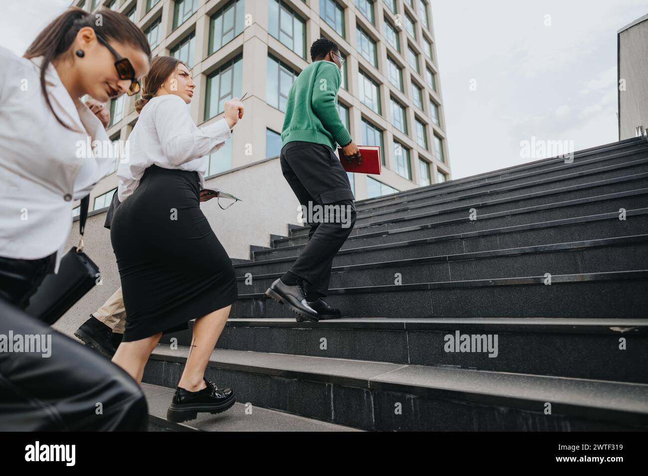 Dynamic startup team walking up stairs for an outdoor business meeting ...
