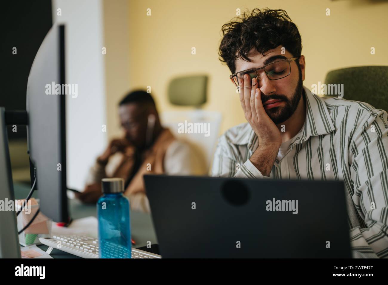 Tired male employee rubbing his eyes after hard day at work Stock Photo ...