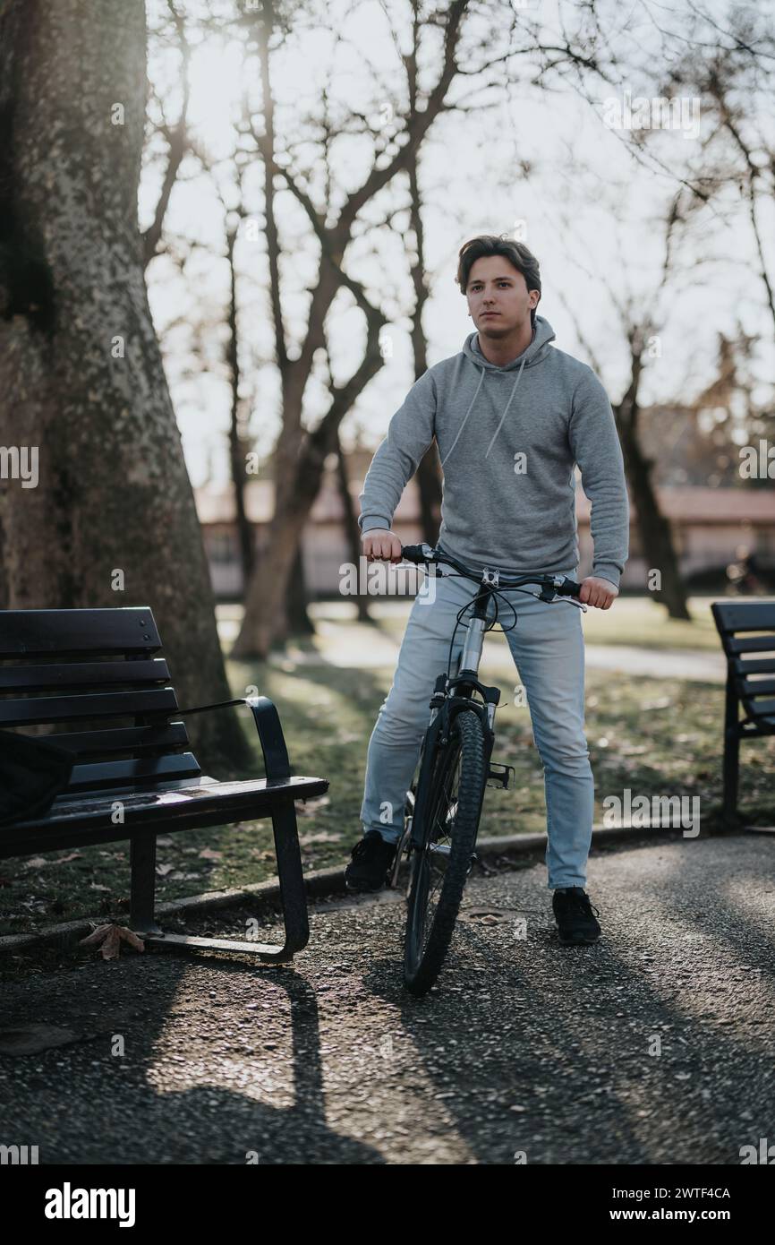 Active man pausing during a bike ride in a peaceful park setting Stock ...