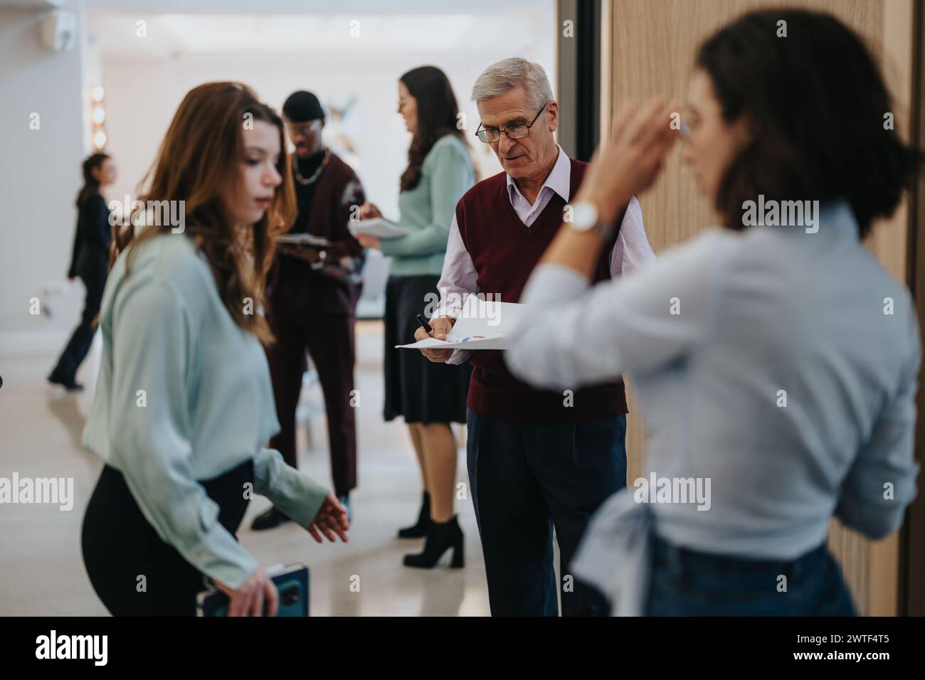 Multi generational group of business employees engaged in casual ...