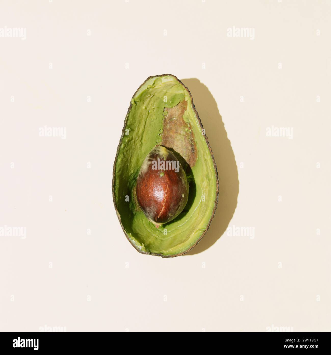 Emptied shell of an avocado and seed avocado with copy space on beige ...