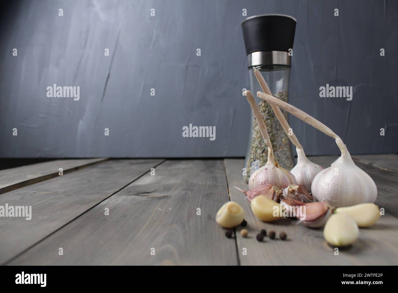 A salt shaker with seasoning and salt garlic lies next to it on a gray ...
