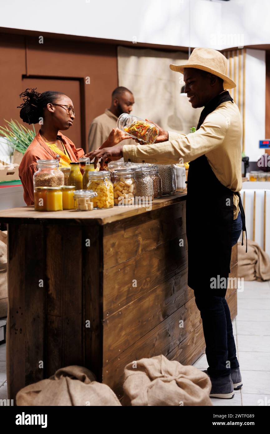 African American eco shopkeeper explaining local, organic fruits ...