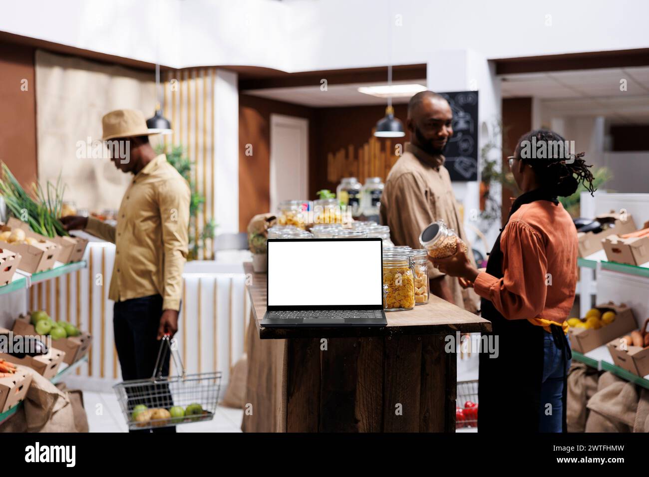 A laptop with an empty white screen display is set down on a wooden ...