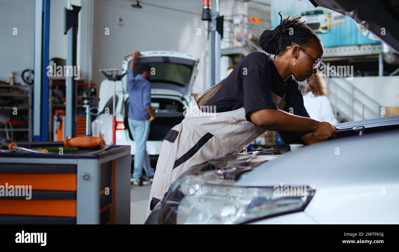 Meticulous employee in repair shop using torque wrench to tighten ...