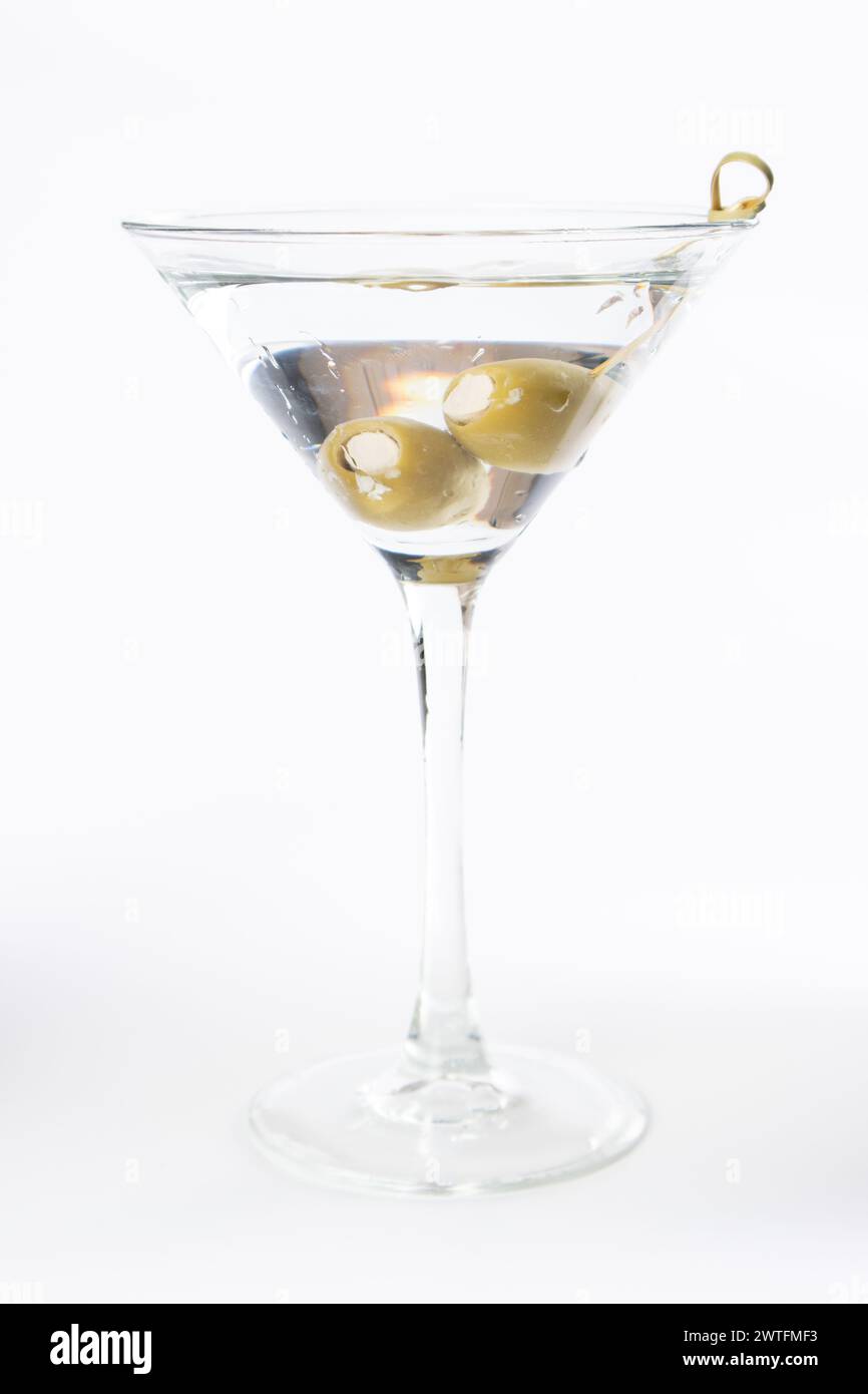 Chilled gin martini with bleu cheese stuffed olives on a bright white ...
