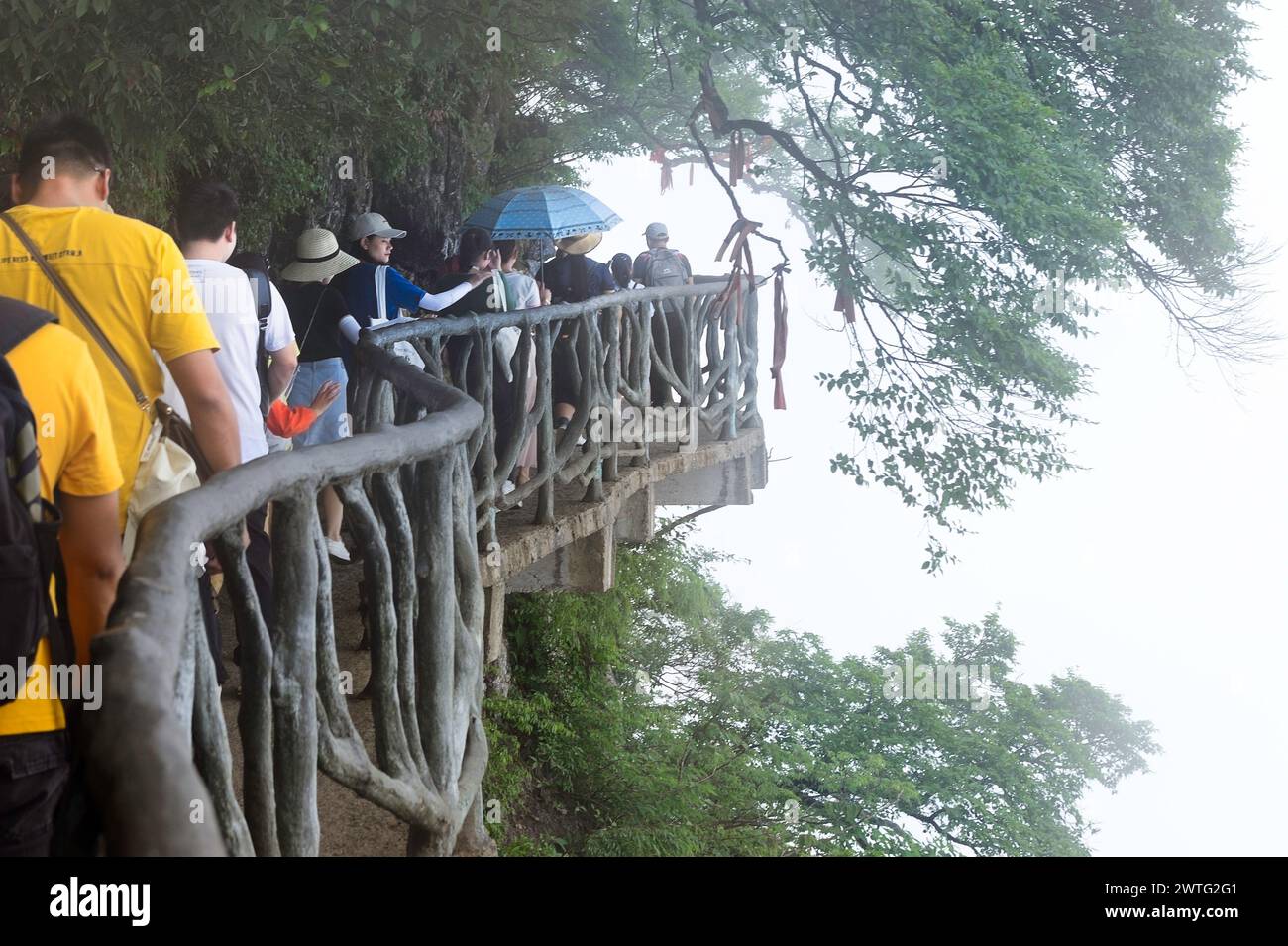 Tourists walk along the Cliff Hanging Walkway, which clings to the ...