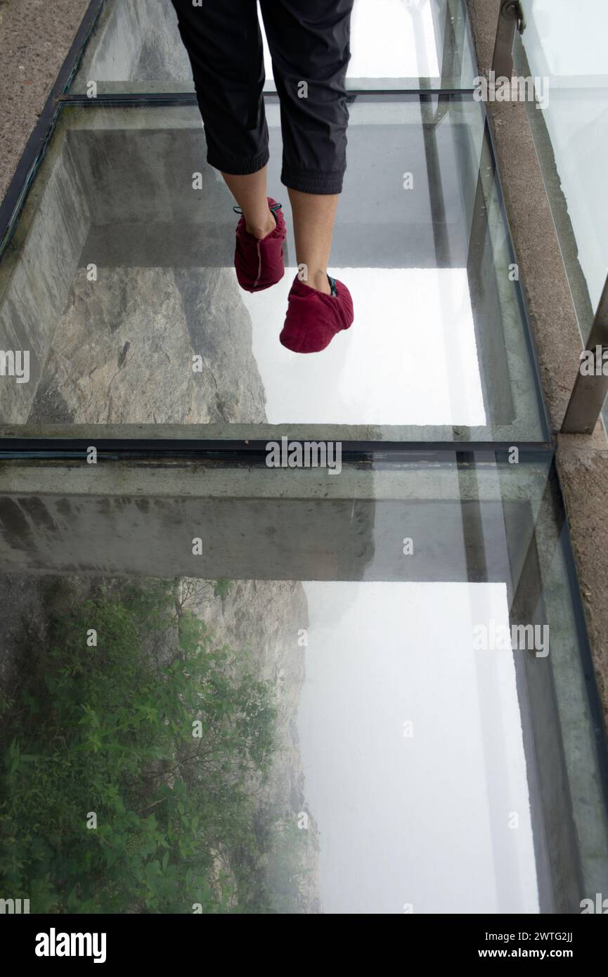 Tourists walk along the Cliff Hanging Walkway, which clings to the ...