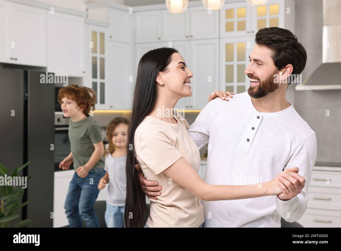 Happy family having fun at home. Couple dancing while children jumping ...