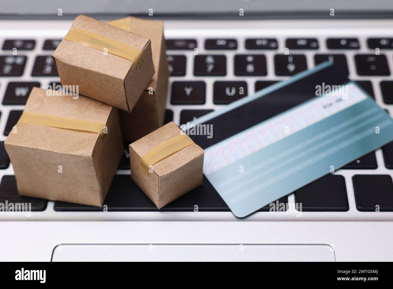 Internet shopping. Small cardboard boxes and credit card on laptop ...
