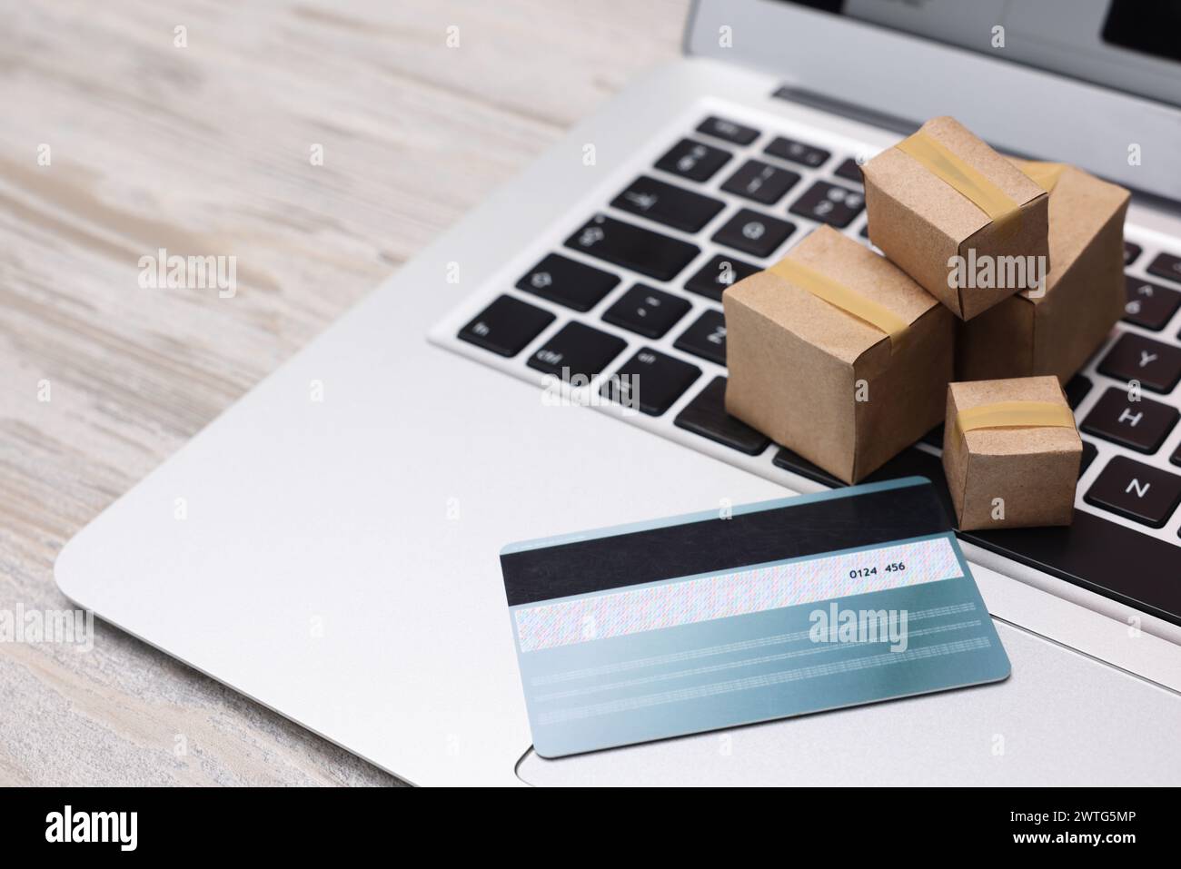 Internet shopping. Small cardboard boxes, credit card and laptop on ...