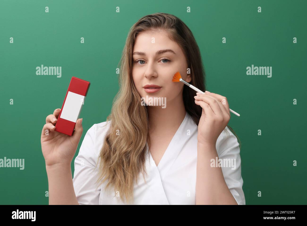 Cosmetologist with cosmetic product and brush on green background Stock ...