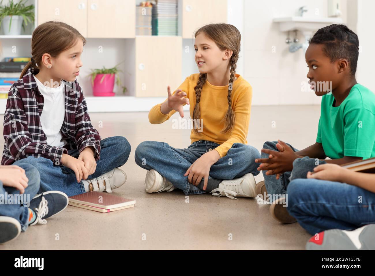 Cute children discussing in classroom at school Stock Photo - Alamy