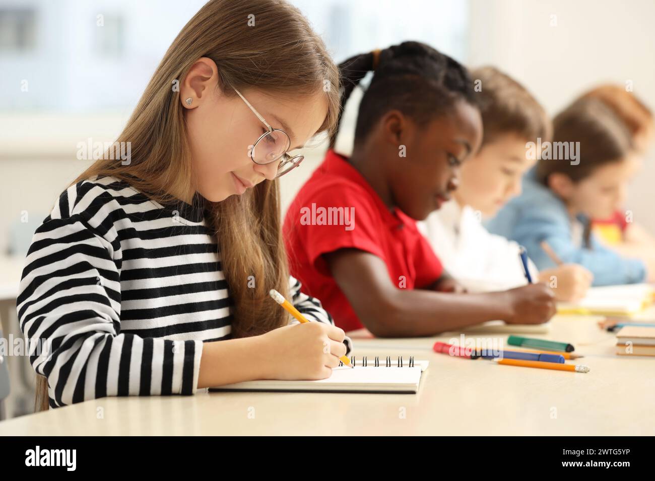 Cute children studying in classroom at school Stock Photo - Alamy
