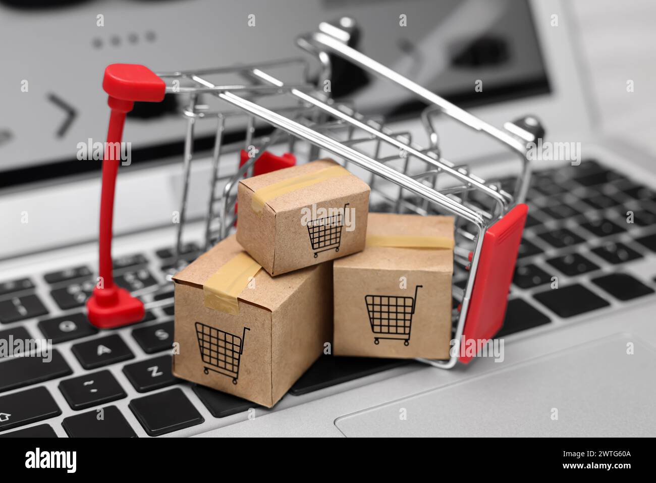 Internet store. Small cardboard boxes and shopping cart on laptop ...