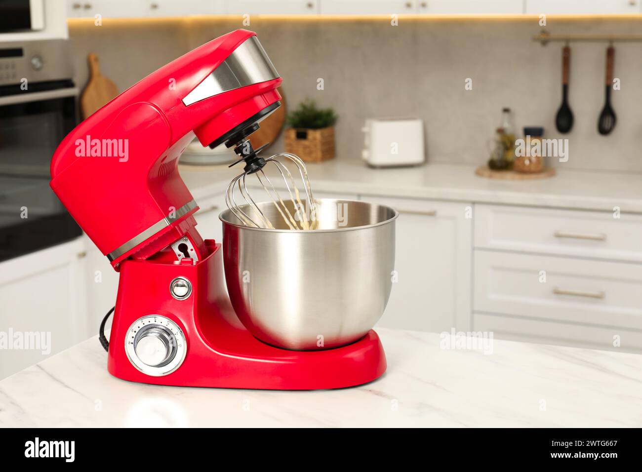 Modern red stand mixer on white marble table in kitchen, space for text ...