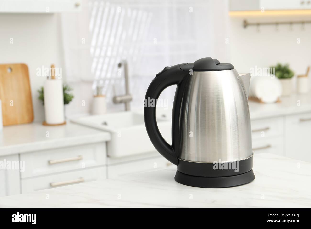 Modern electric kettle on table in kitchen. Space for text Stock Photo ...