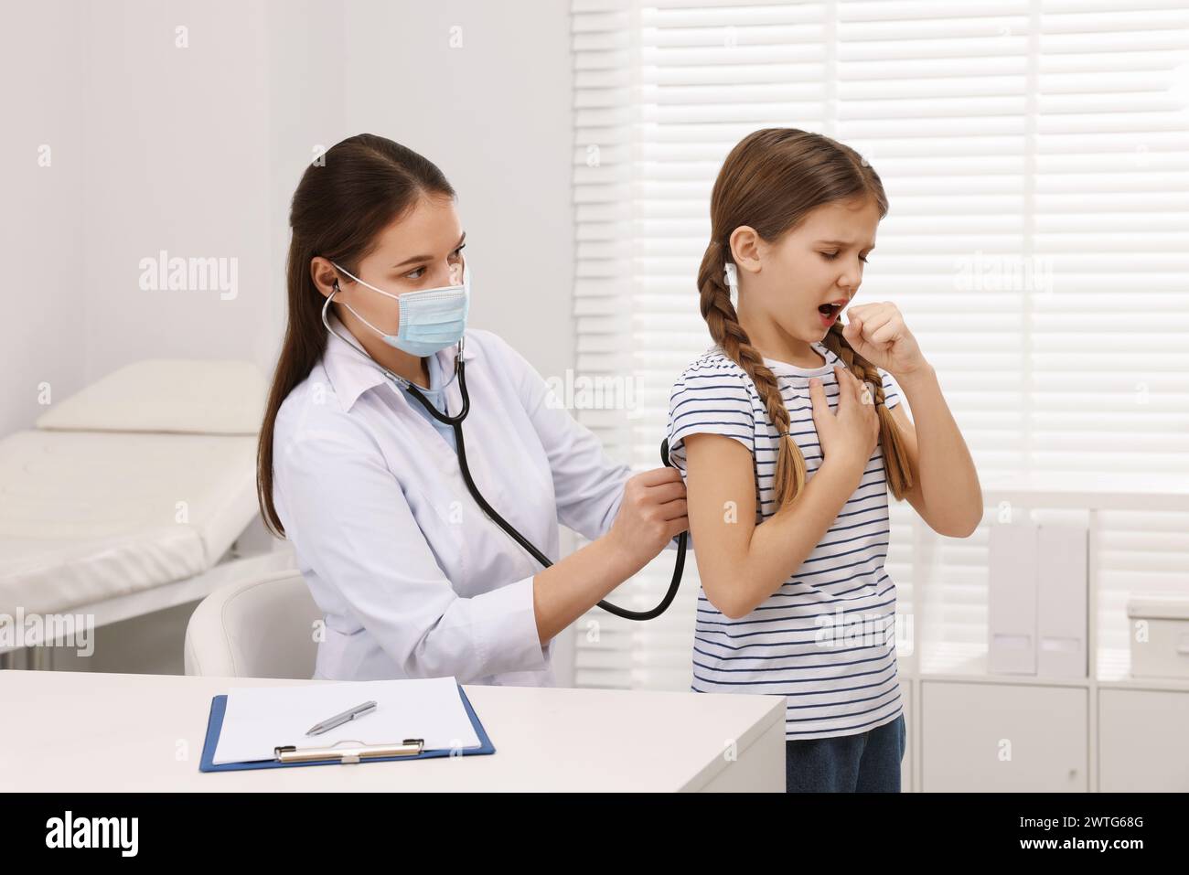 Doctor examining coughing girl in hospital. Cold symptoms Stock Photo ...