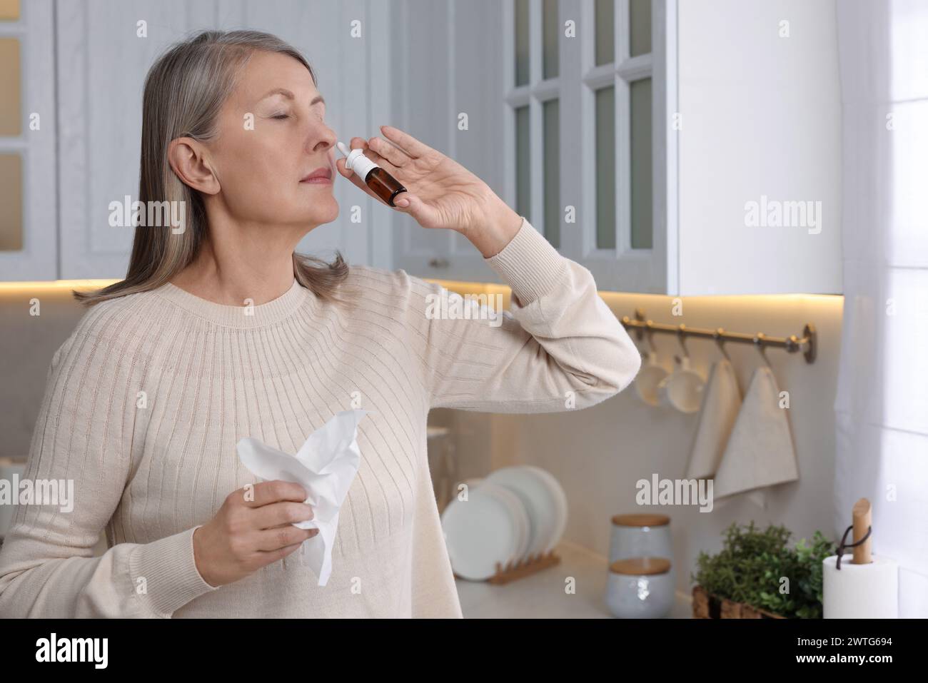 Medical drops. Woman using nasal spray indoors Stock Photo - Alamy