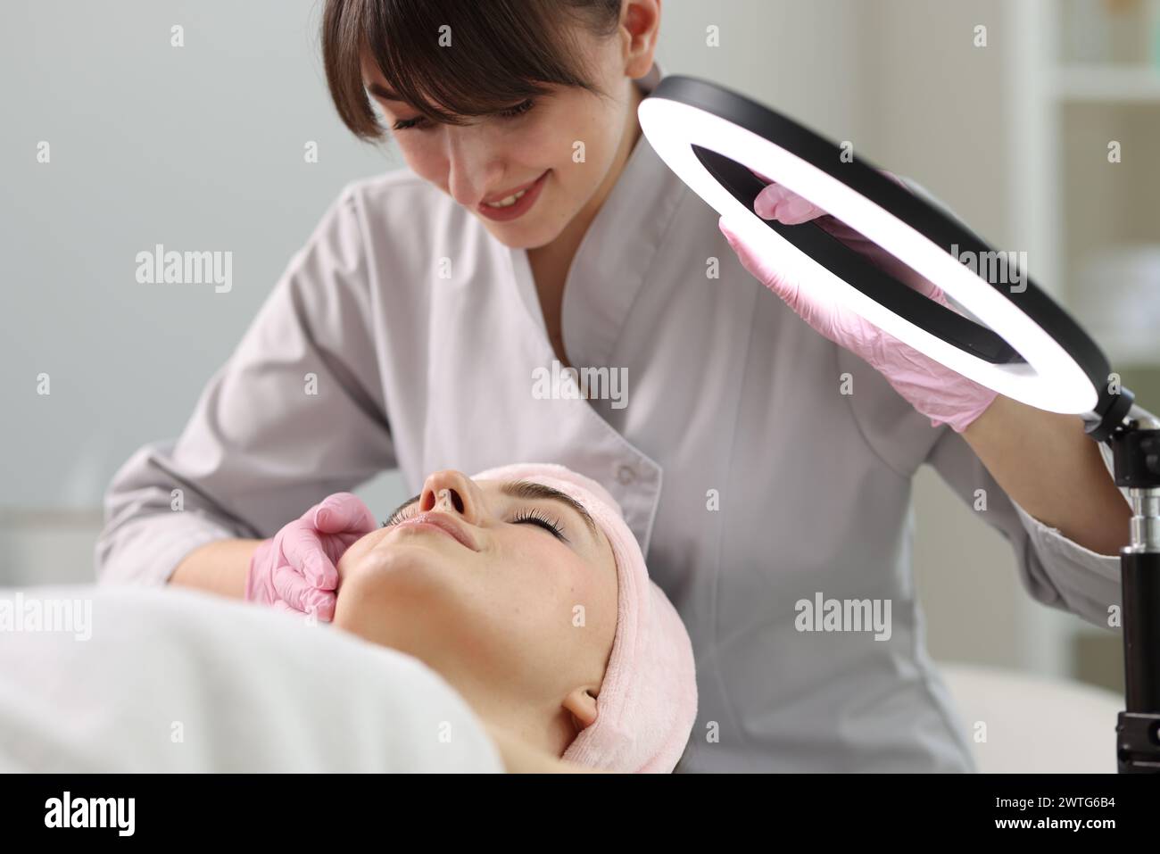 Cosmetologist making face massage to client in clinic Stock Photo - Alamy