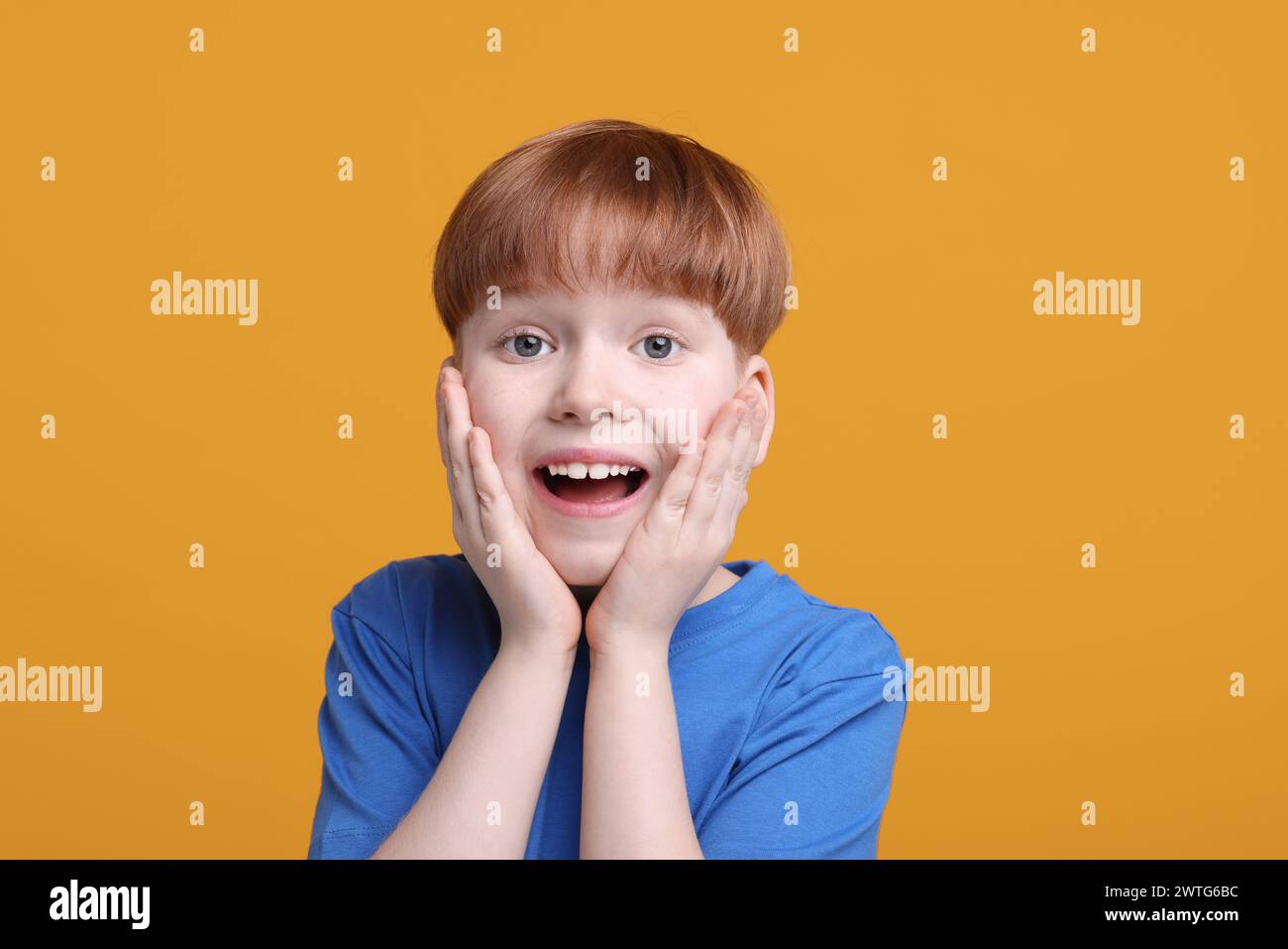 Portrait of surprised little boy on orange background Stock Photo - Alamy