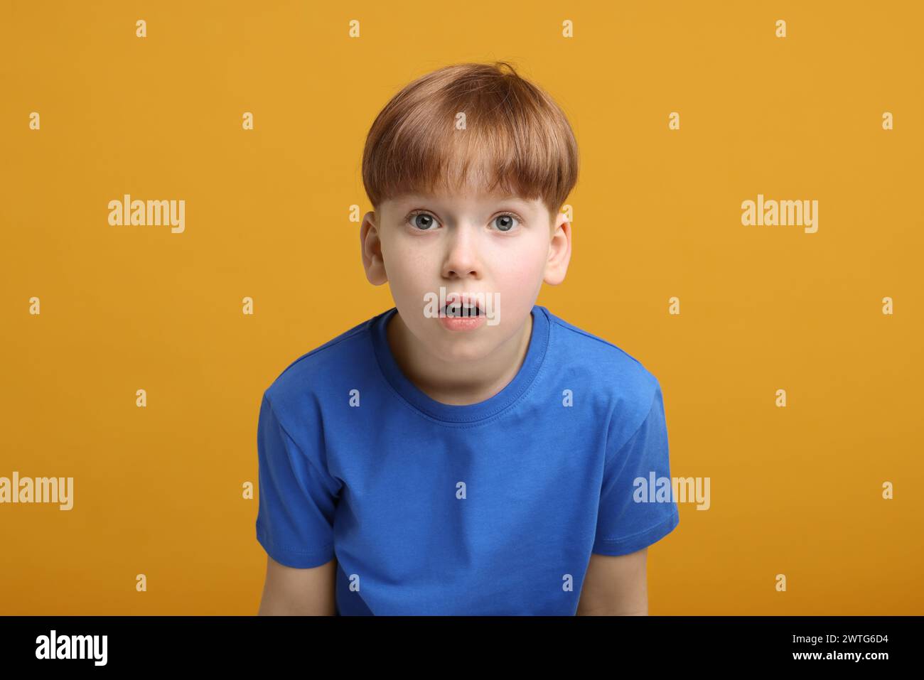 Portrait of surprised little boy on orange background Stock Photo - Alamy