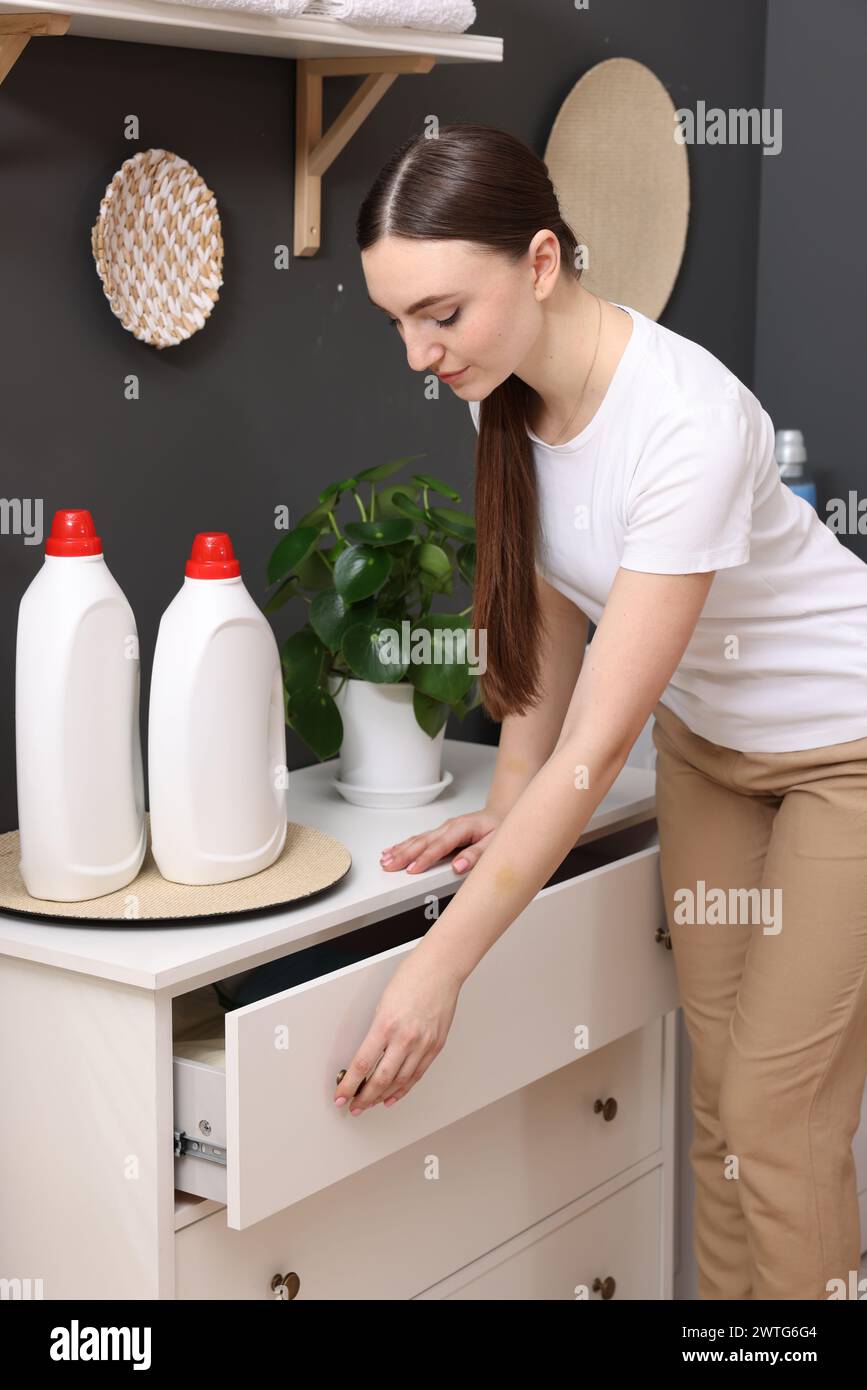 Beautiful woman opening drawer in laundry room Stock Photo - Alamy