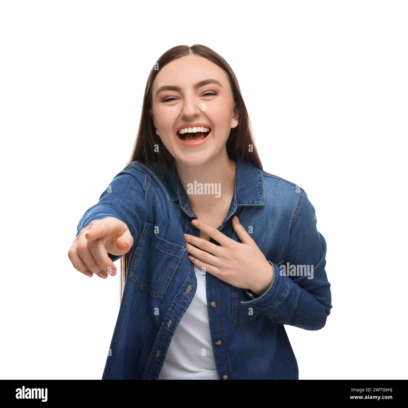 Beautiful woman pointing at something and laughing on white background ...