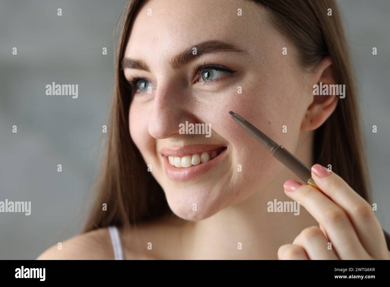 Smiling woman drawing freckles with pen indoors, closeup Stock Photo ...
